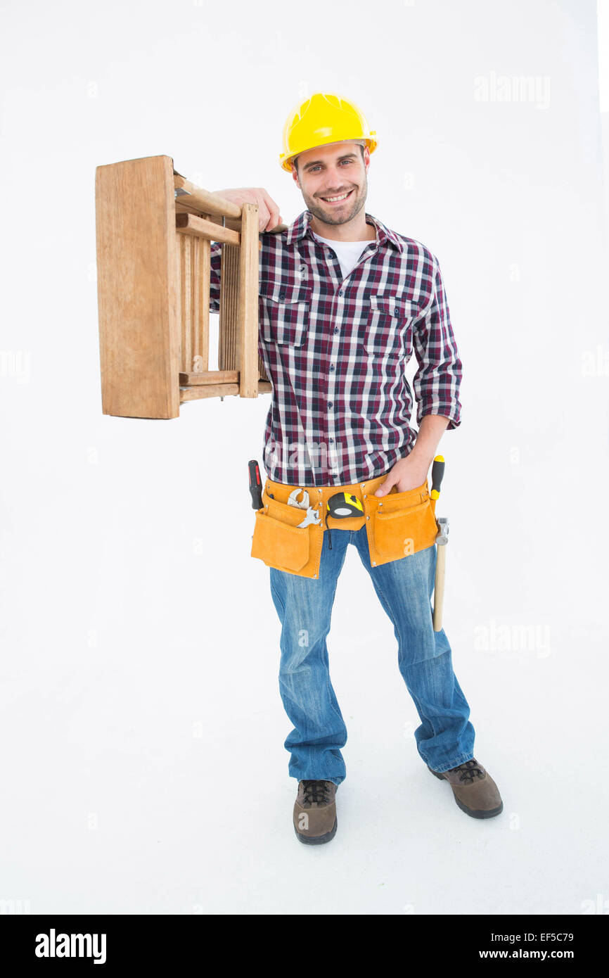 Confident handyman carrying ladder Stock Photo - Alamy