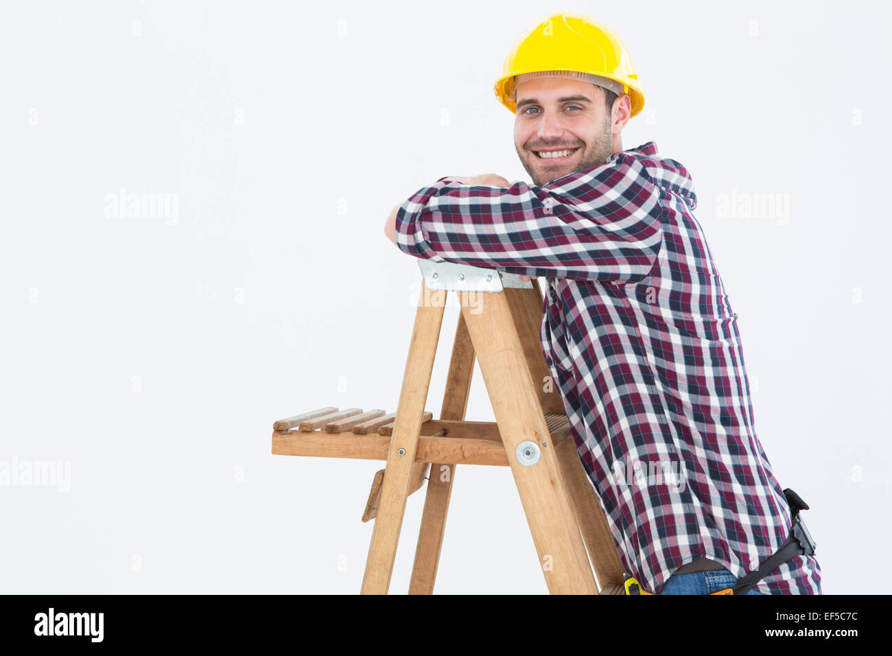 Smiling repairman climbing ladder Stock Photo - Alamy