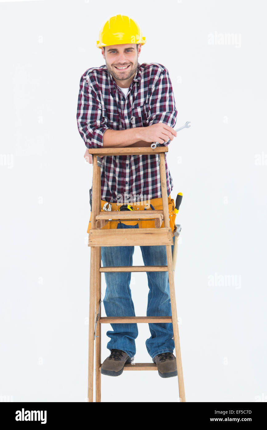 Repairman holding spanner while climbing ladder Stock Photo - Alamy