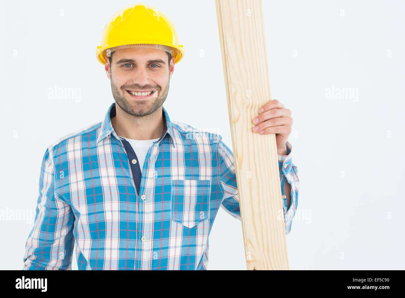 Happy carpenter holding wooden plank Stock Photo - Alamy