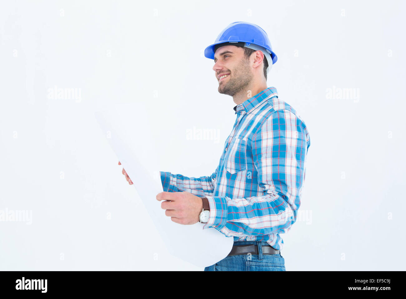 Smiling engineer looking away while holding blueprint Stock Photo - Alamy
