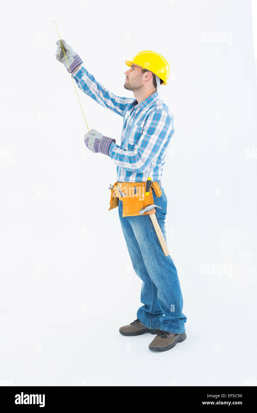Construction worker using measure tape Stock Photo - Alamy