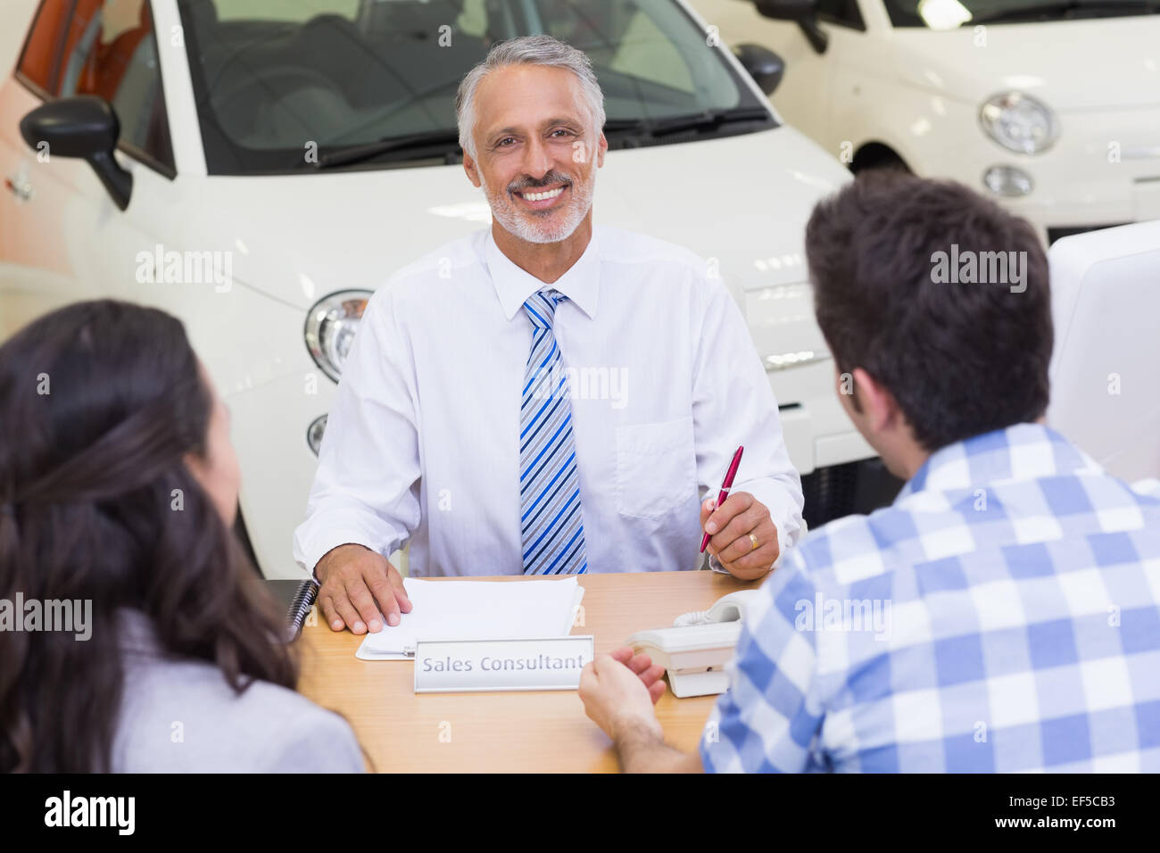 Salesman speaking with his clients Stock Photo - Alamy