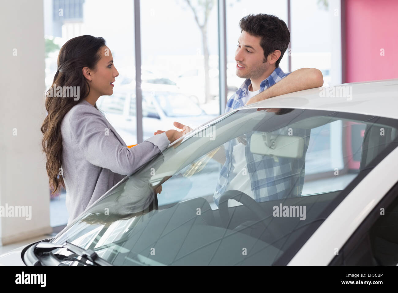 Smiling couple talking next to a car Stock Photo - Alamy