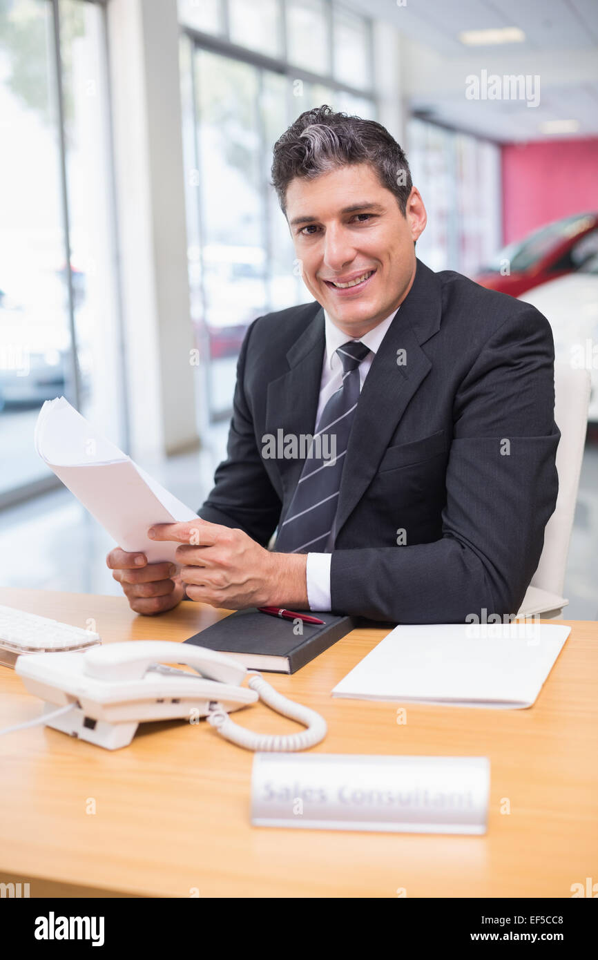 Smiling salesperson holding a document Stock Photo - Alamy