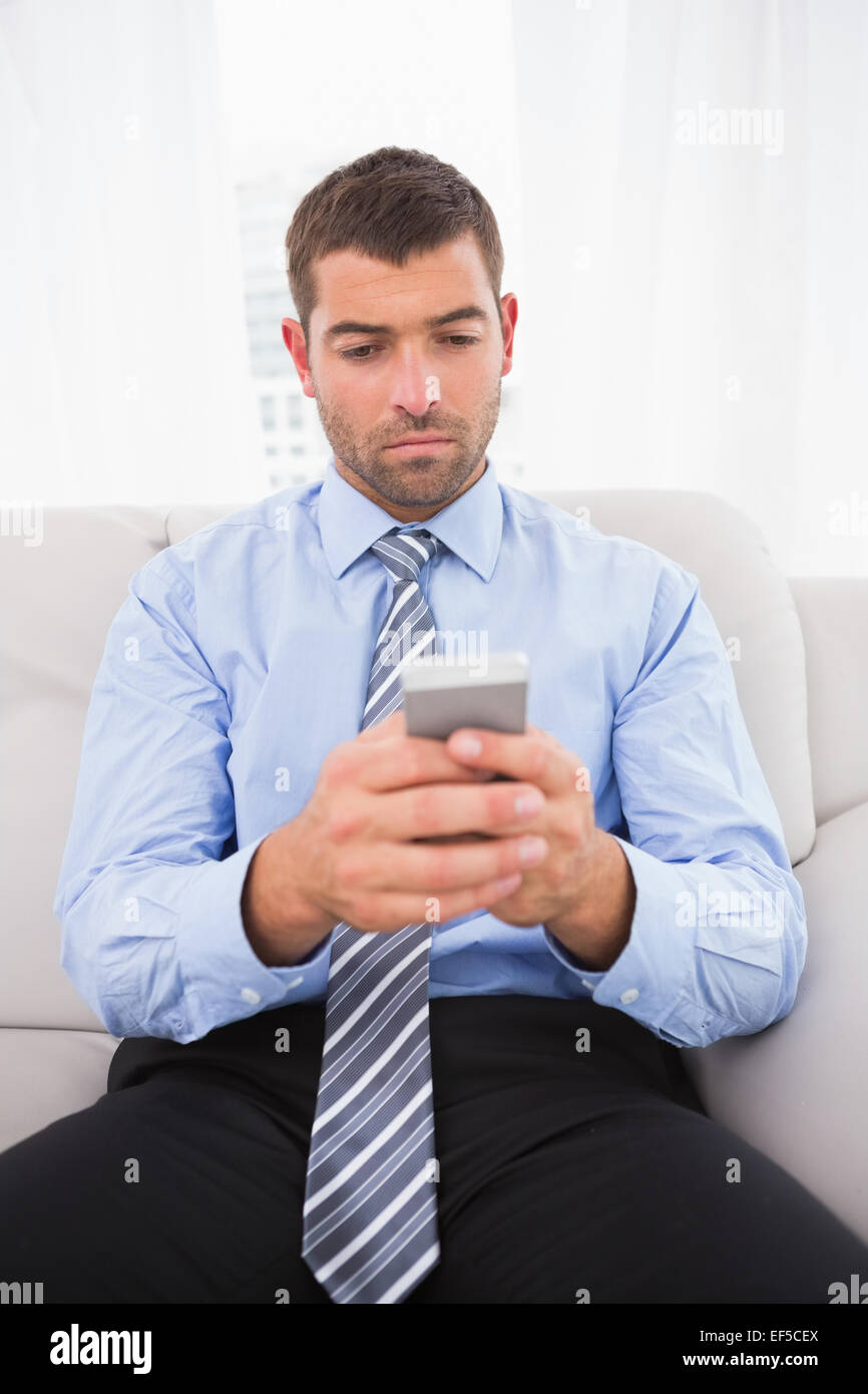 Concentrate man using his phone at home Stock Photo - Alamy