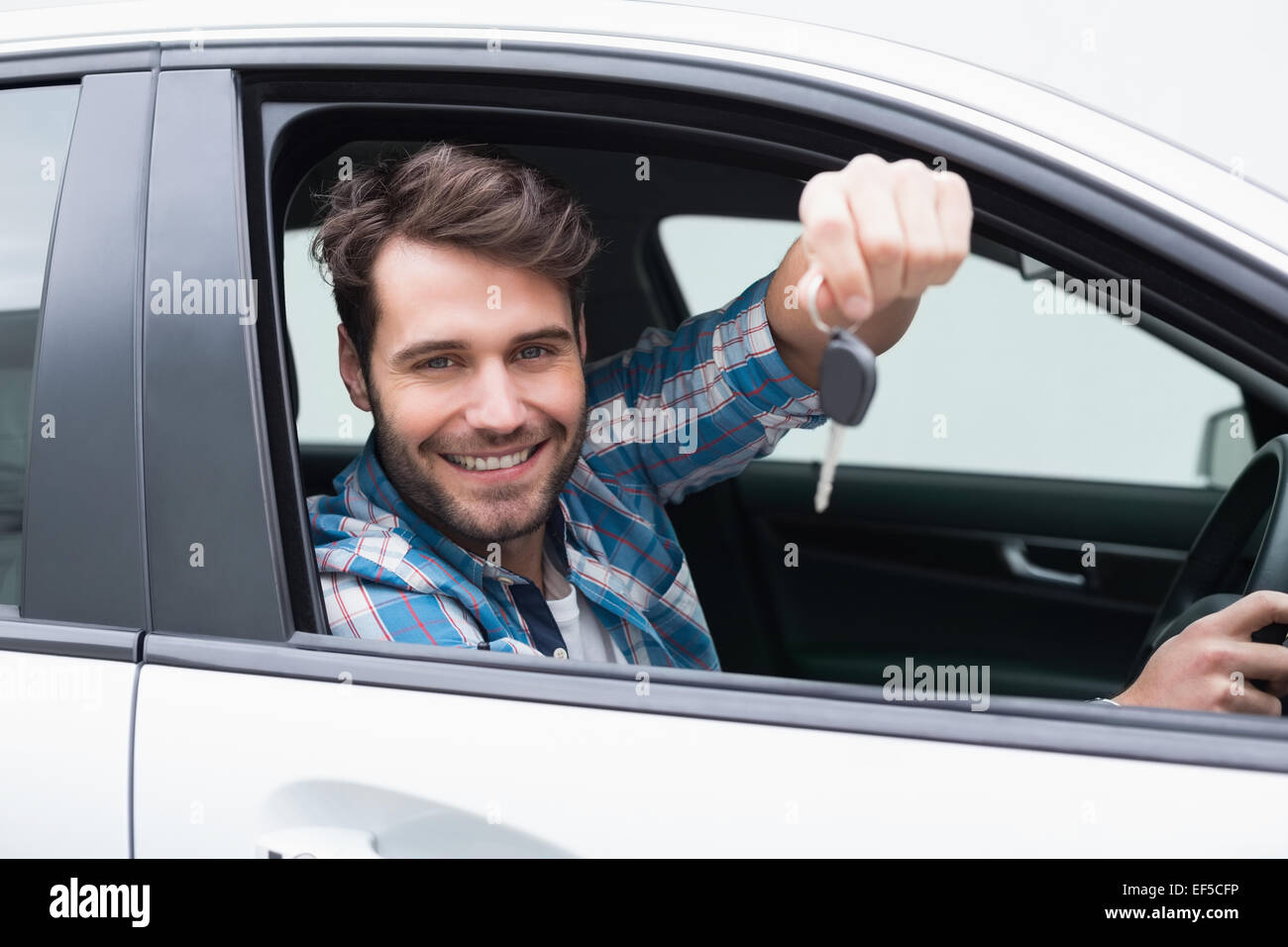 Young man smiling at camera showing key Stock Photo - Alamy