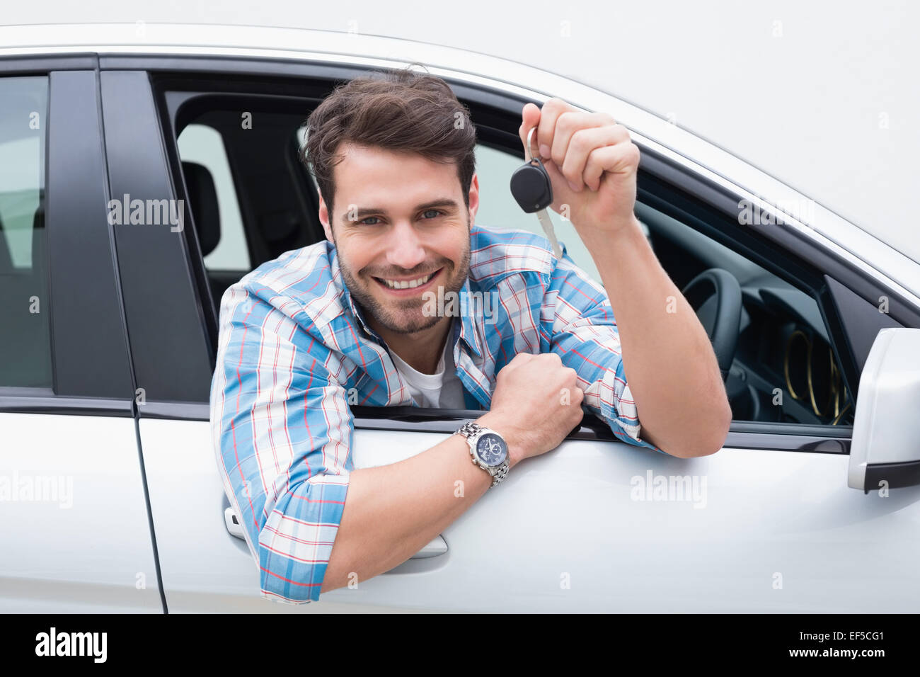 Young man smiling and showing key Stock Photo - Alamy