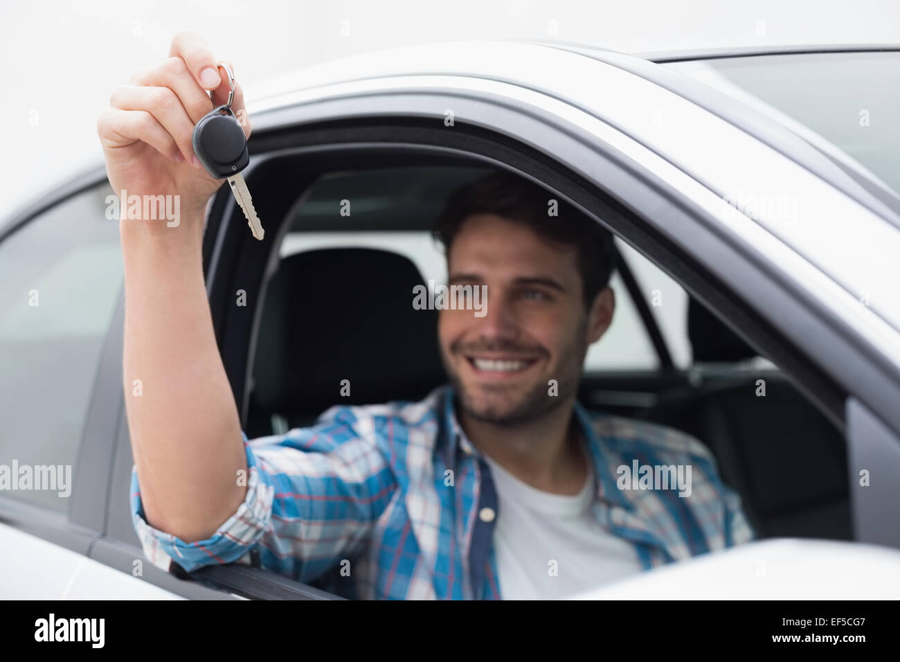 Young man smiling and holding key Stock Photo - Alamy