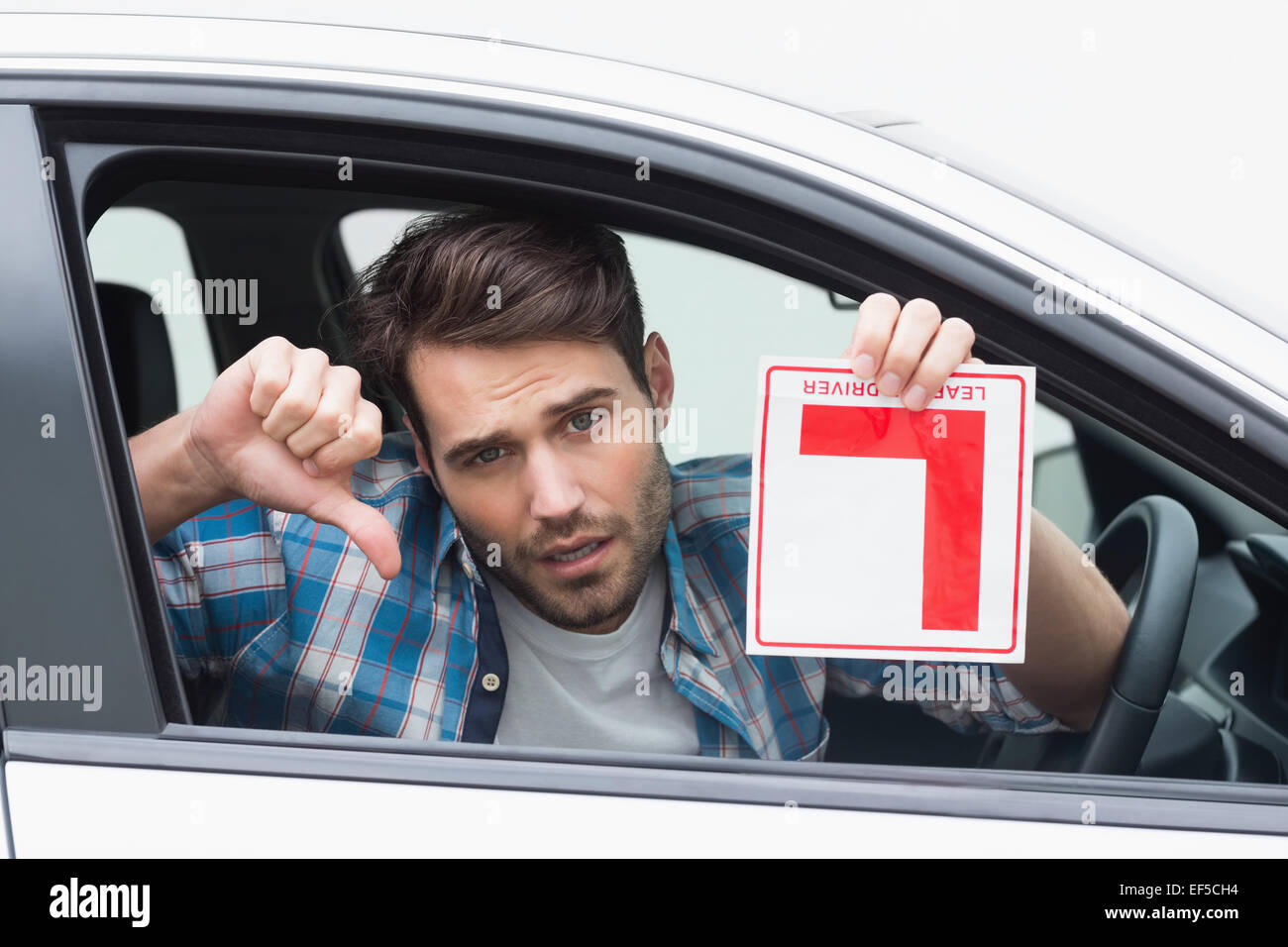 Learner driver smiling and holding l plate Stock Photo - Alamy