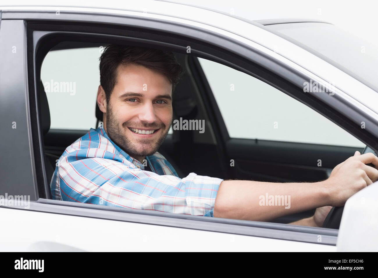 Young man driving and smiling Stock Photo - Alamy