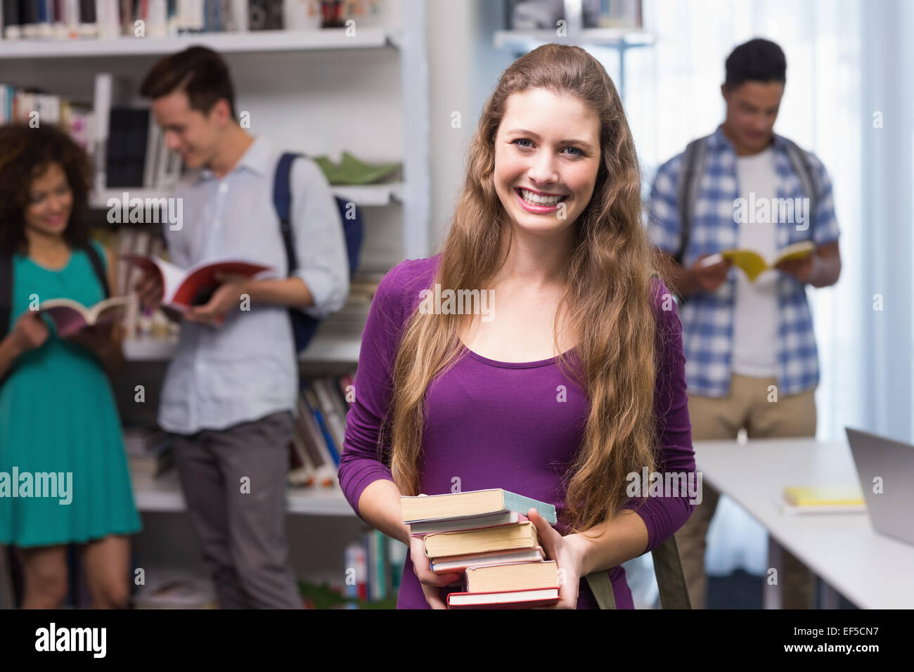 Student carrying small pile of books Stock Photo - Alamy