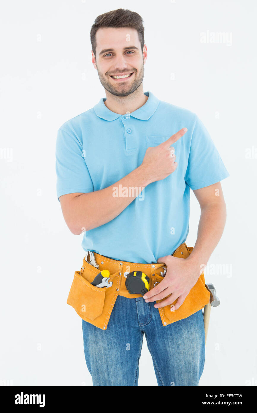 Happy carpenter pointing against white background Stock Photo - Alamy