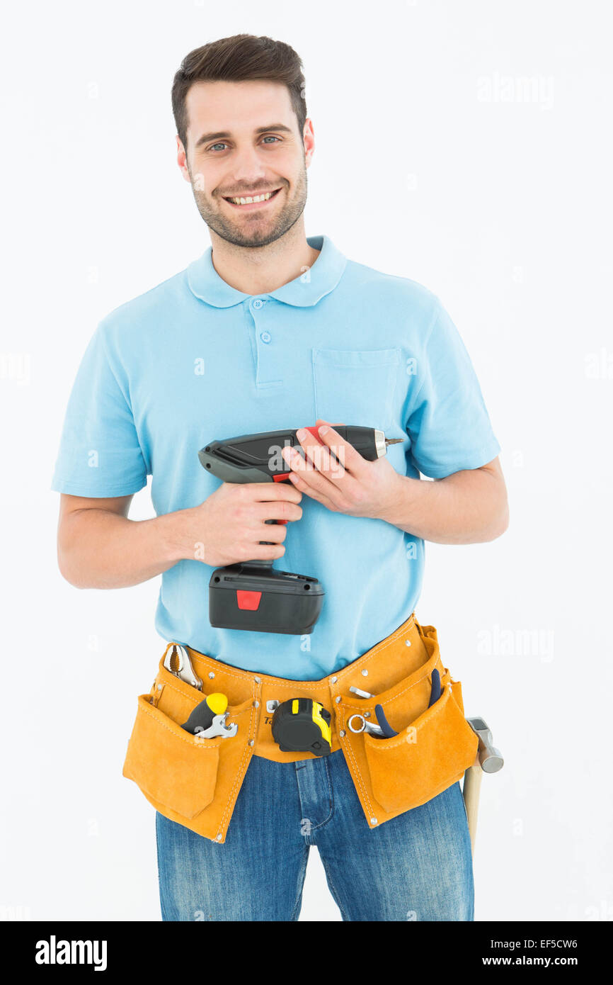 Happy repairman holding hand drill Stock Photo - Alamy