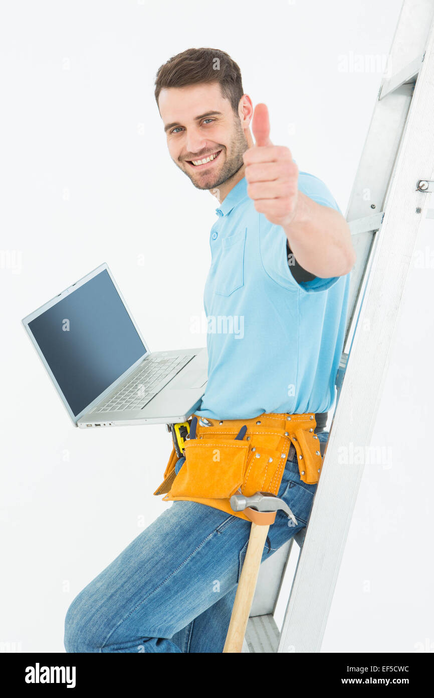 Construciton worker gesturing thumbs up while leaning on ladder Stock ...