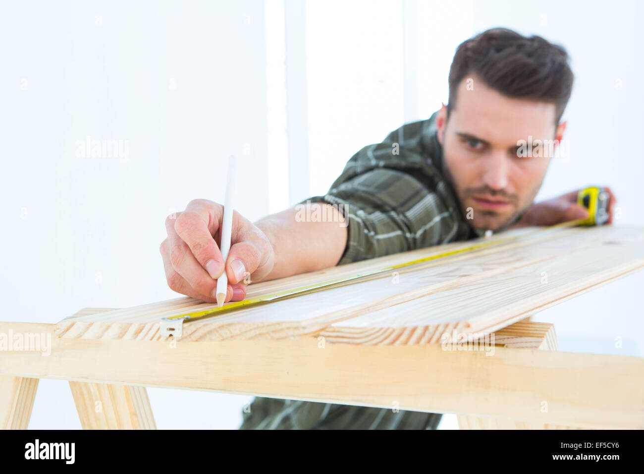 Worker marking on wooden plank Stock Photo - Alamy