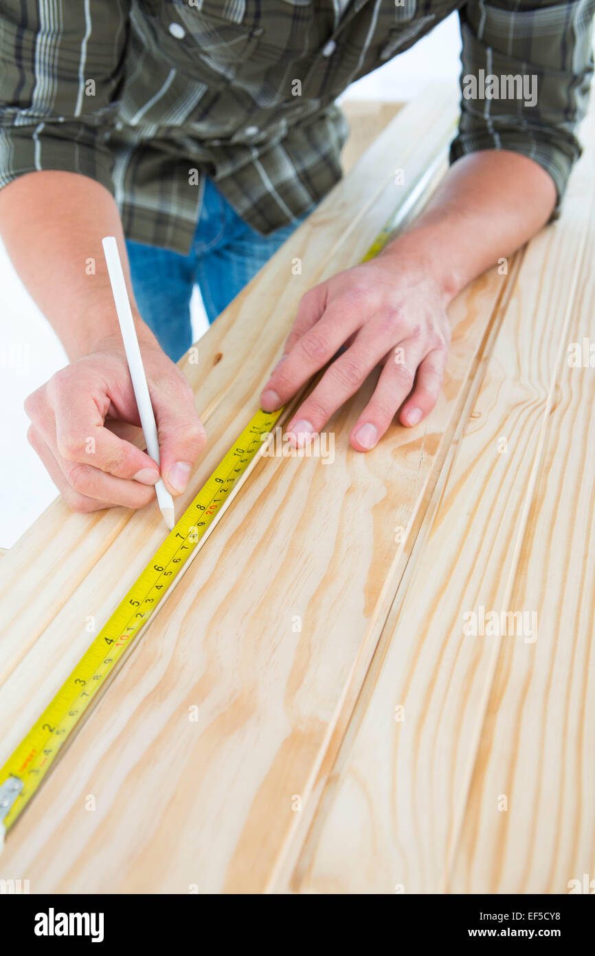 Carpenter marking with tape measure on wooden plank Stock Photo - Alamy