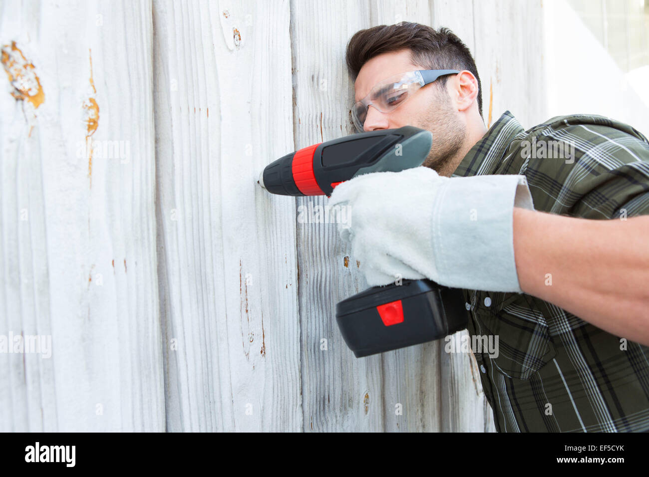 Carpenter drilling wooden cabin Stock Photo - Alamy