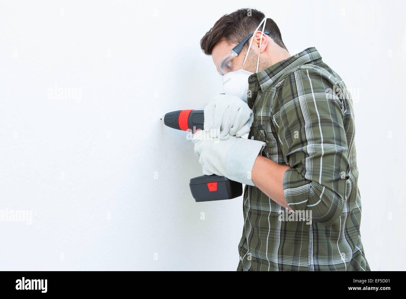 Young man using drill machine hi-res stock photography and images - Alamy