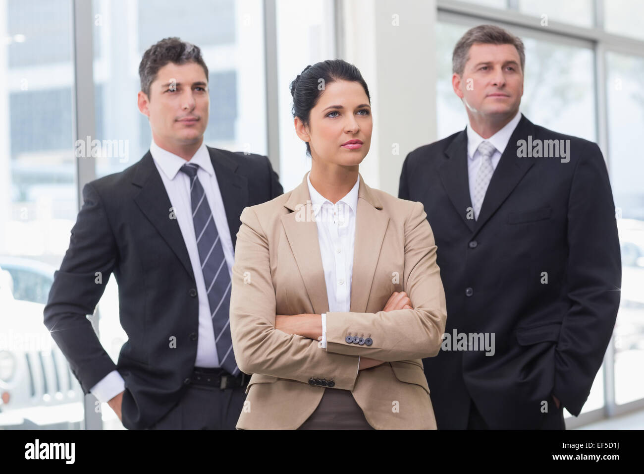 Serious business team standing with arms crossed Stock Photo - Alamy