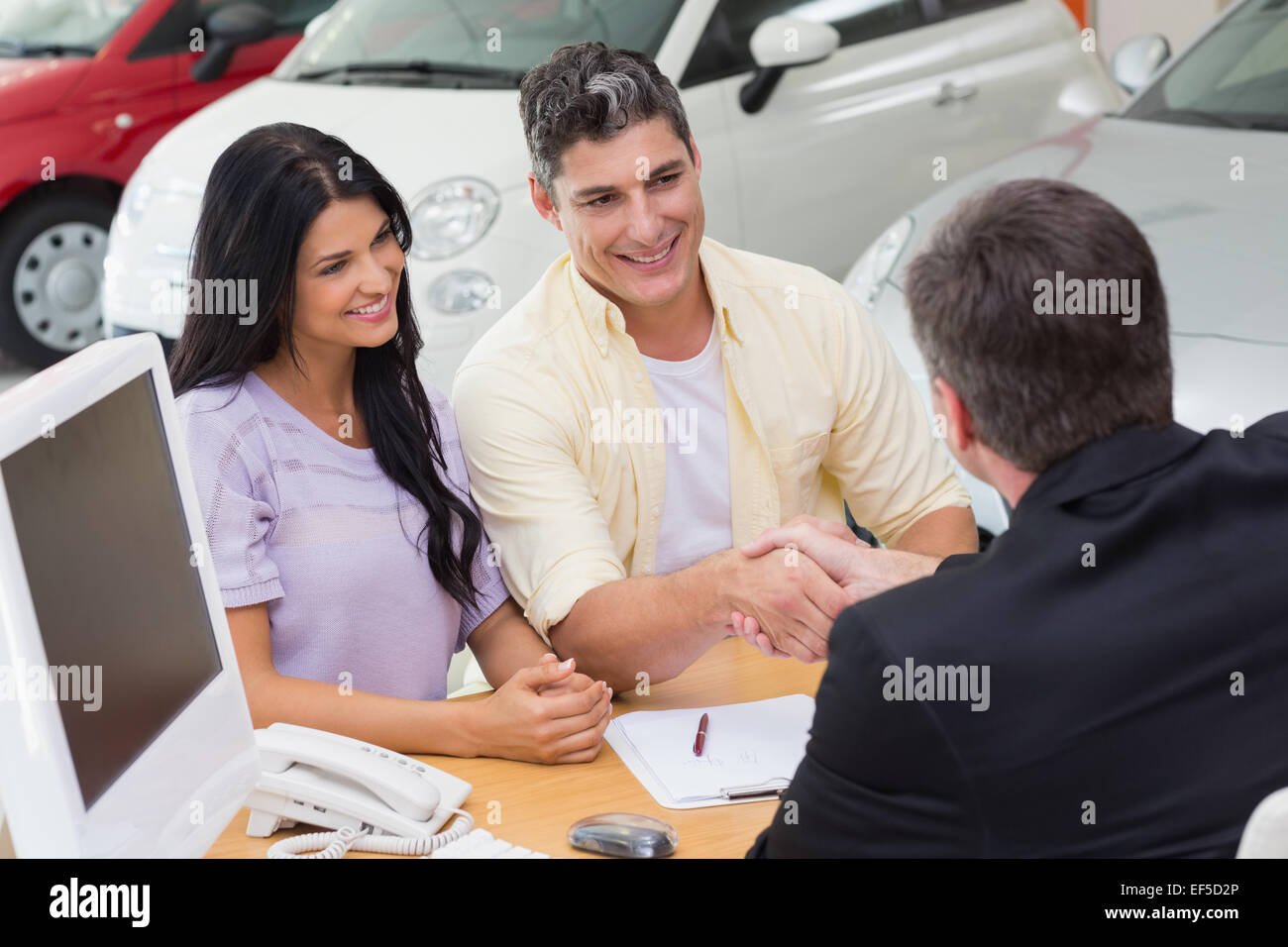 Smiling salesman shaking a customer hand Stock Photo - Alamy