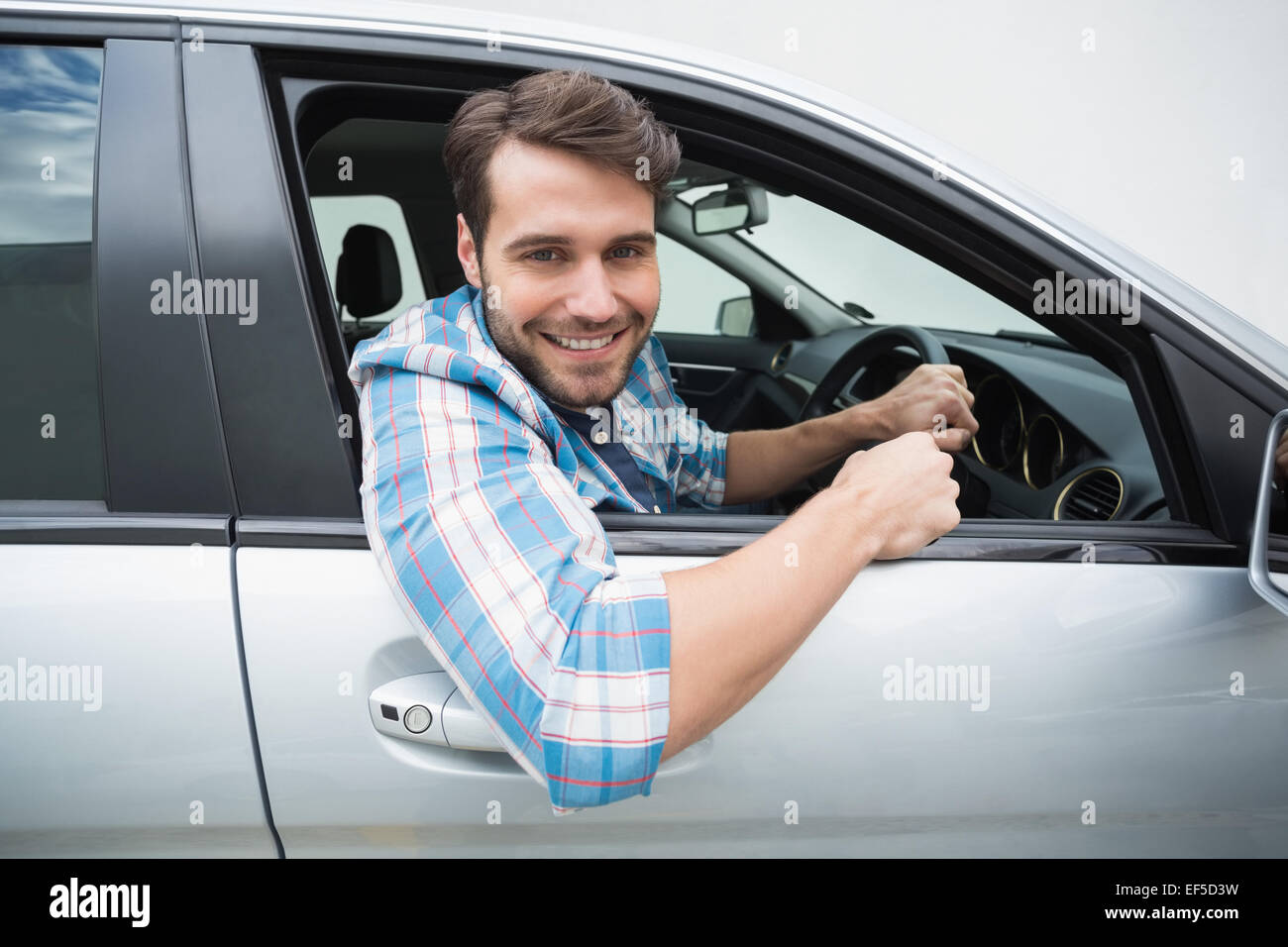 Young man smiling and driving Stock Photo - Alamy