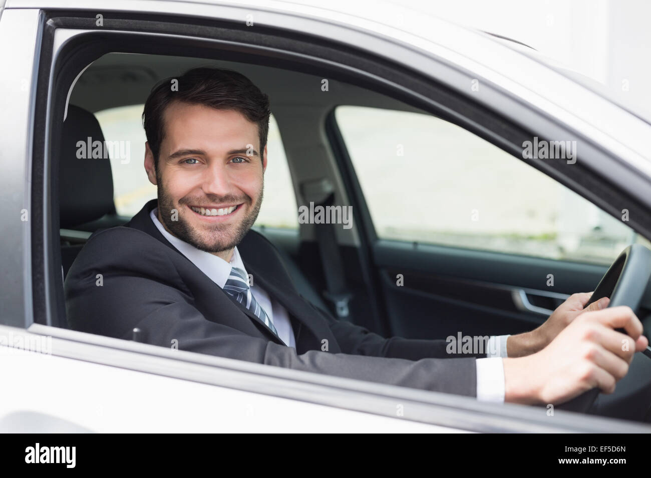 Businessman sitting in drivers seat Stock Photo - Alamy
