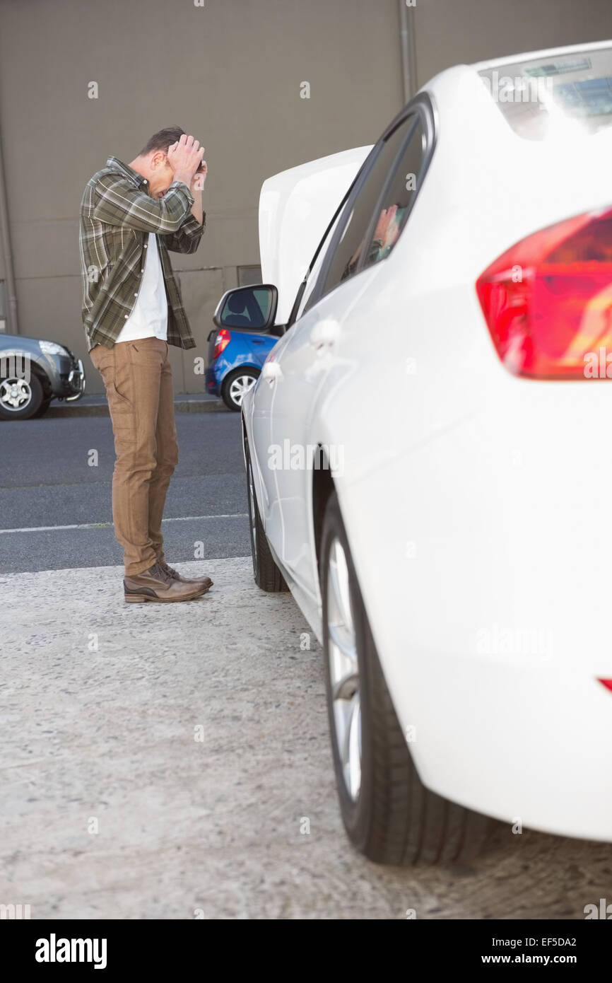 Upset man checking his car engine after breaking down Stock Photo - Alamy