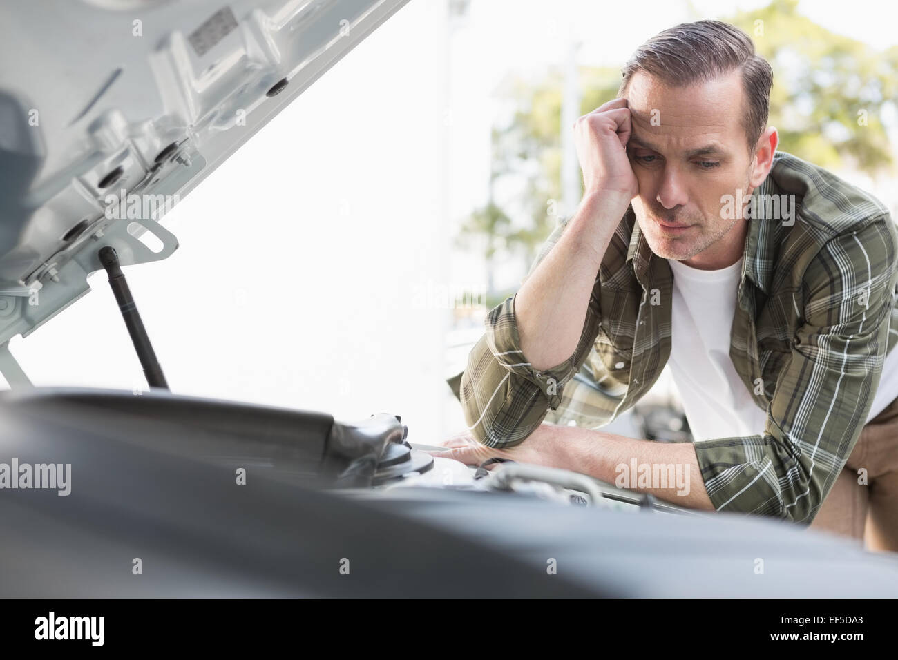 Upset man checking his car engine after breaking down Stock Photo - Alamy