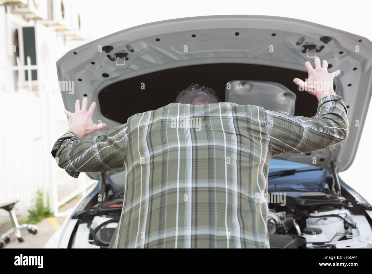 Angry man checking his car engine after breaking down Stock Photo - Alamy
