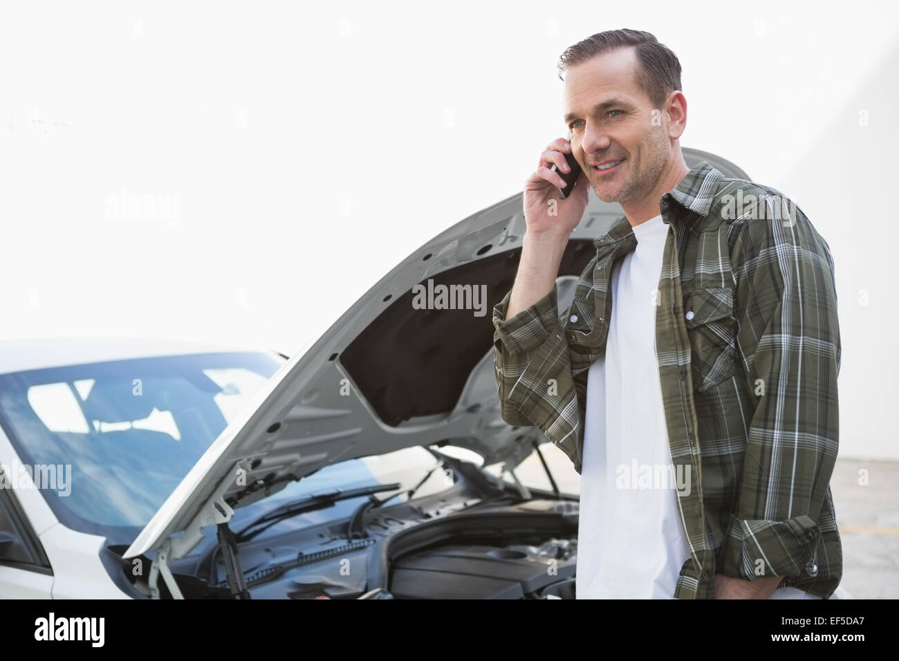 Smiling man calling for assistance after breaking down Stock Photo - Alamy