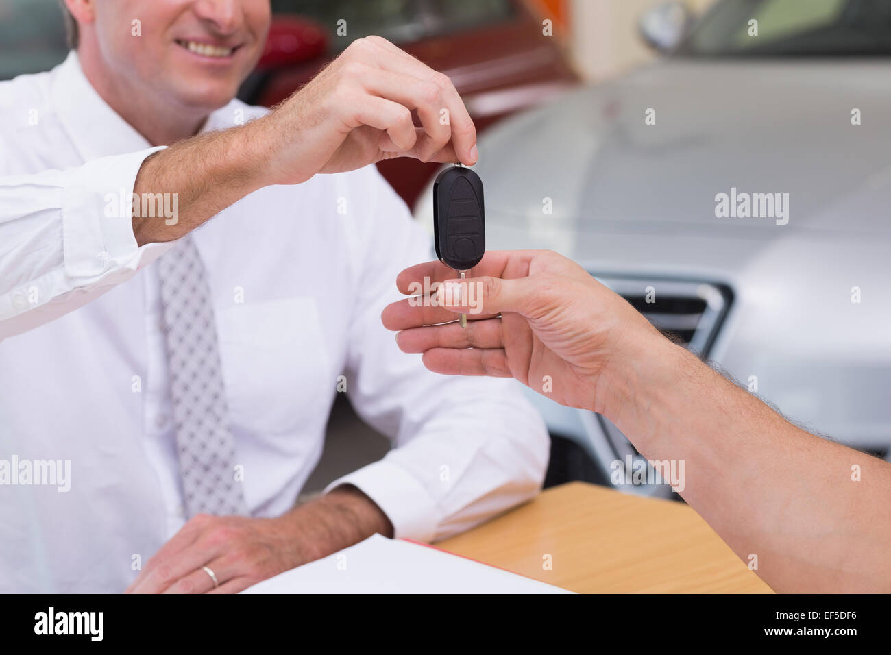 Smiling salesman giving a customer car keys Stock Photo - Alamy