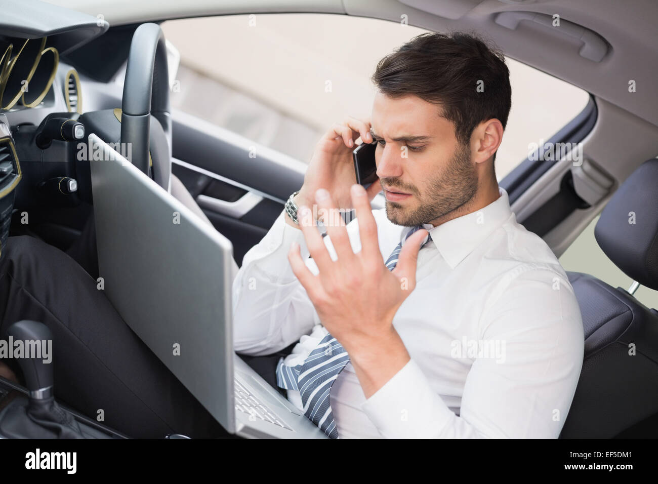 Businessman working in the drivers seat Stock Photo - Alamy