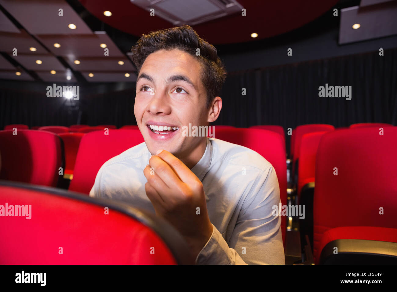 Young man watching a film Stock Photo - Alamy