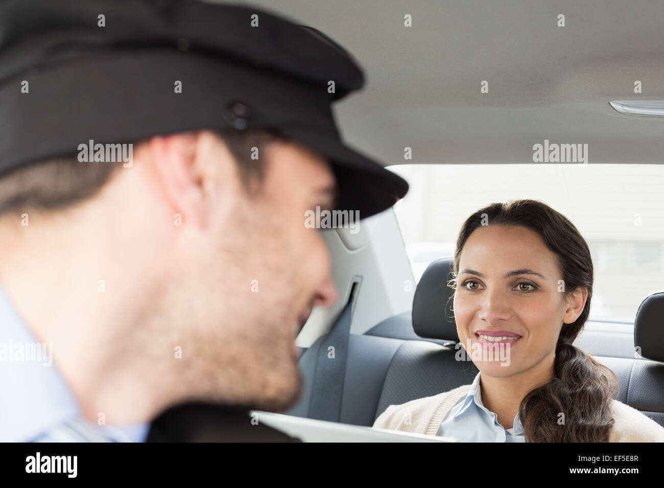 Young businesswoman being chauffeured while working Stock Photo - Alamy