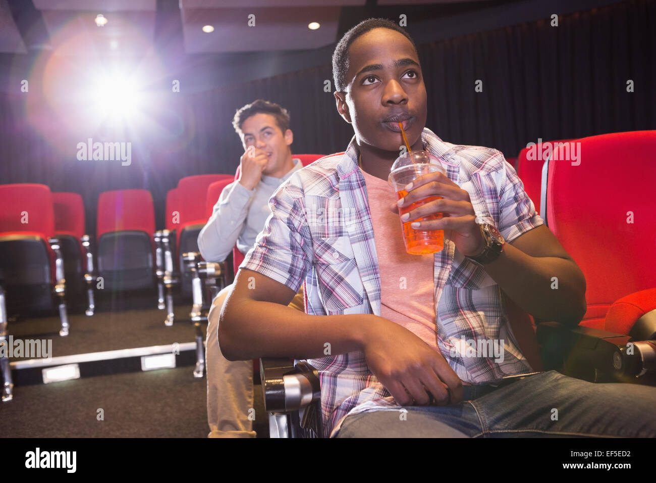 Young friends watching a film Stock Photo - Alamy