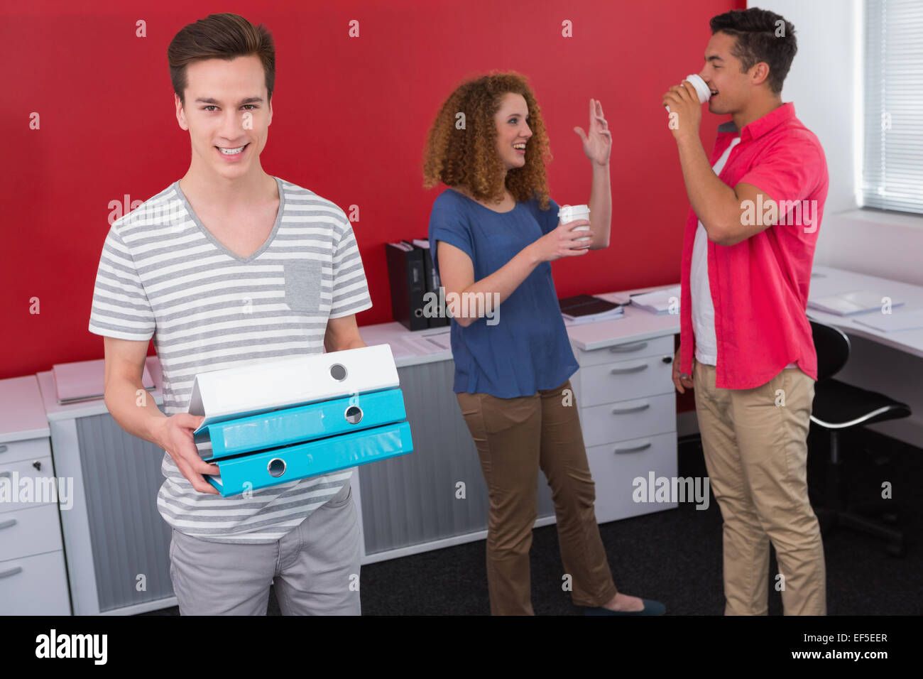 Student holding pile of ring binder near classmates with coffee Stock ...