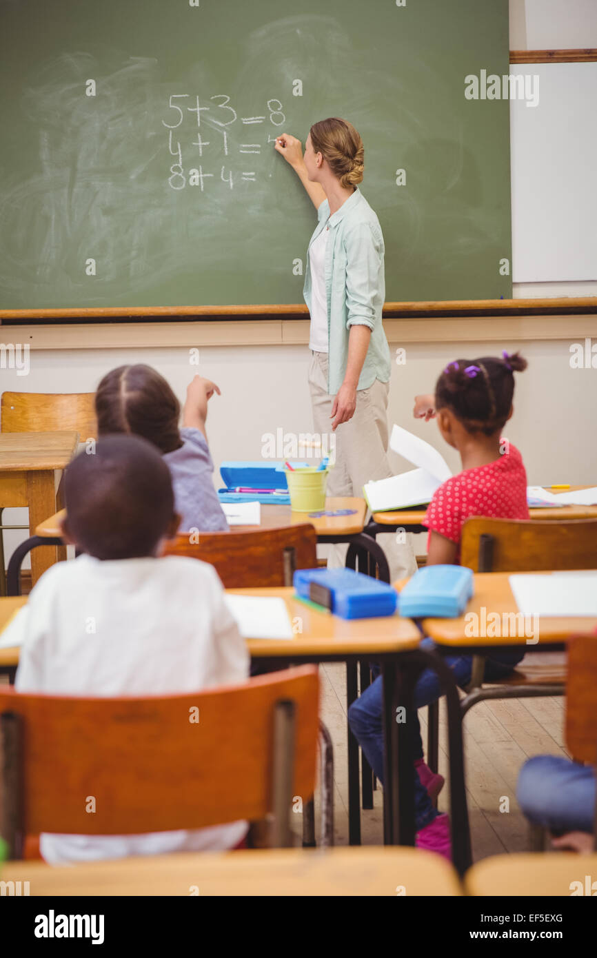 Teacher writing mathematics on board Stock Photo - Alamy