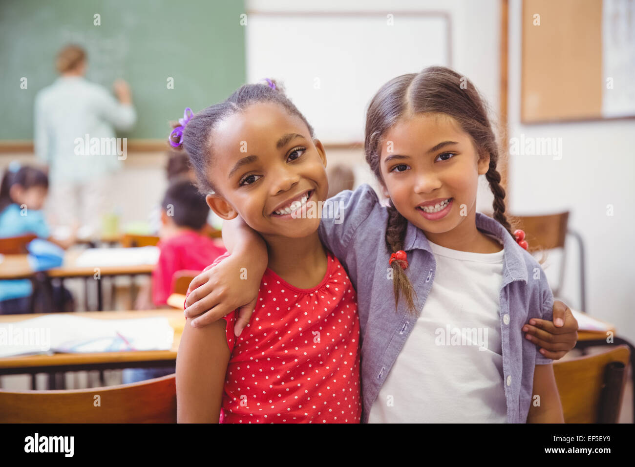 Cute pupils smiling at camera in classroom Stock Photo - Alamy