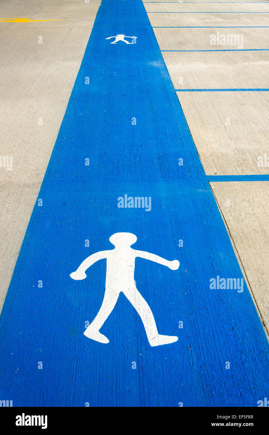 Blue pedestrian path with graphic of person walking Stock Photo - Alamy