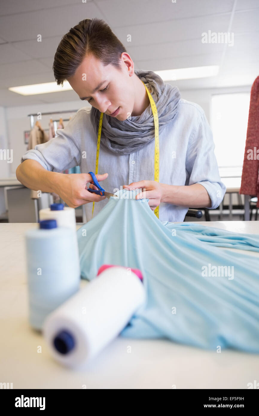 Student cutting fabric with pair of scissors Stock Photo - Alamy
