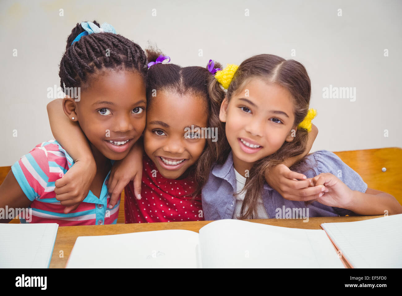 Cute pupils smiling at camera in classroom Stock Photo - Alamy