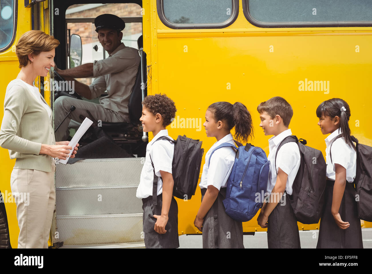 Cute schoolchildren waiting to get on school bus Stock Photo - Alamy