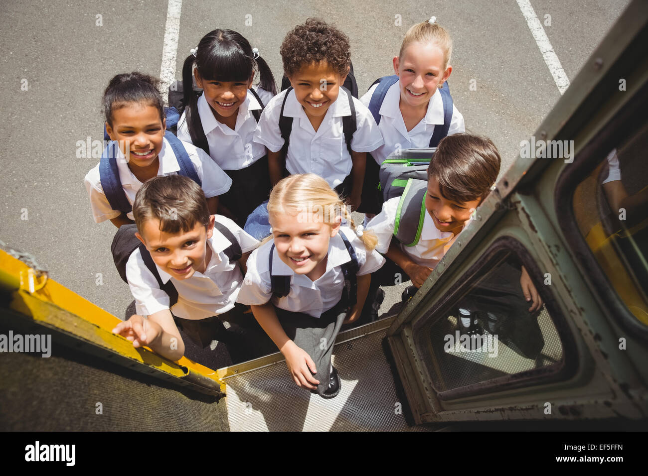 Cute schoolchildren getting on school bus Stock Photo - Alamy
