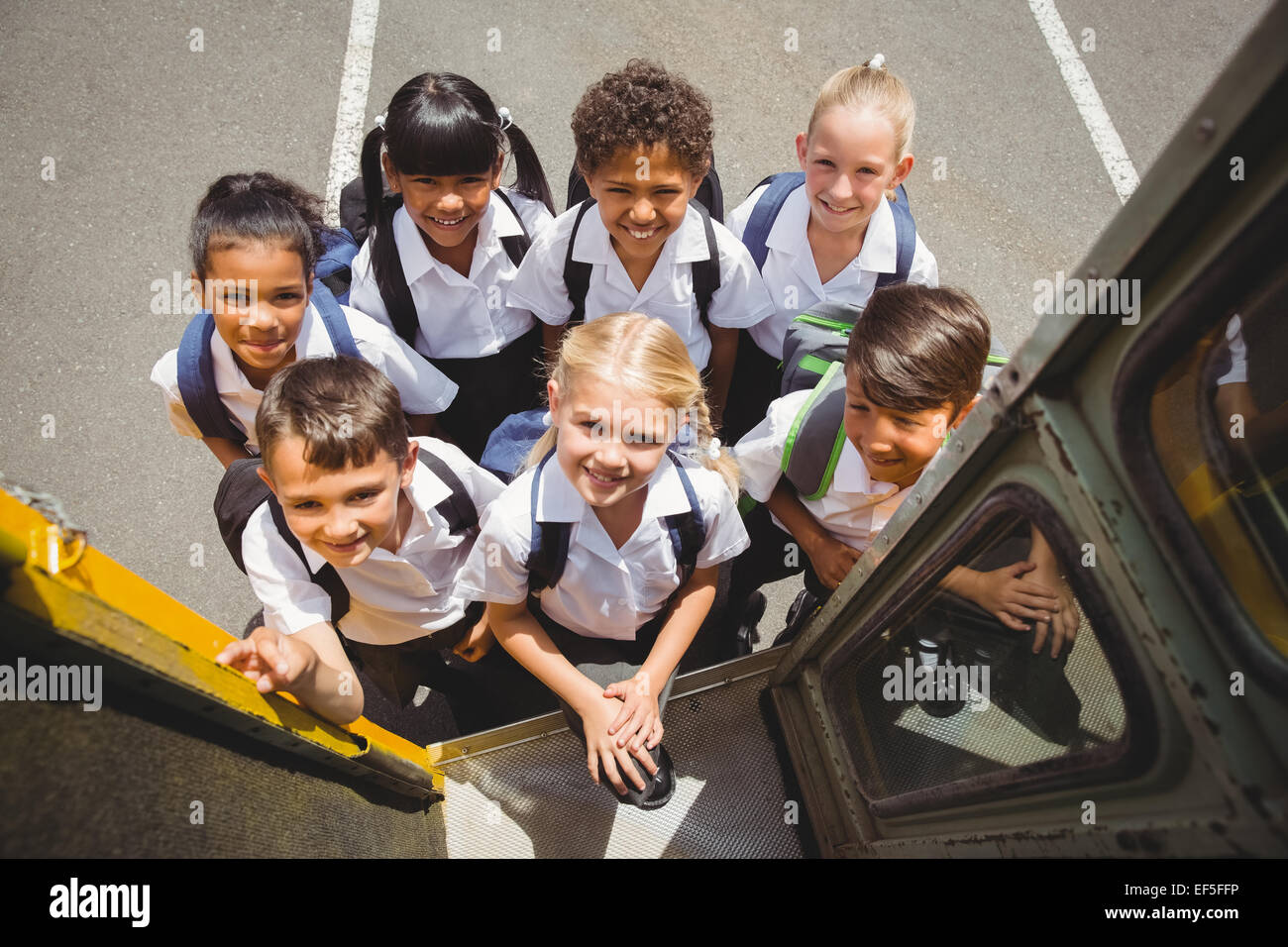 Cute schoolchildren getting on school bus Stock Photo - Alamy