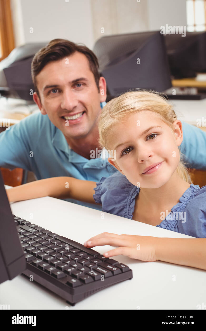 Cute pupil in computer class with teacher Stock Photo - Alamy