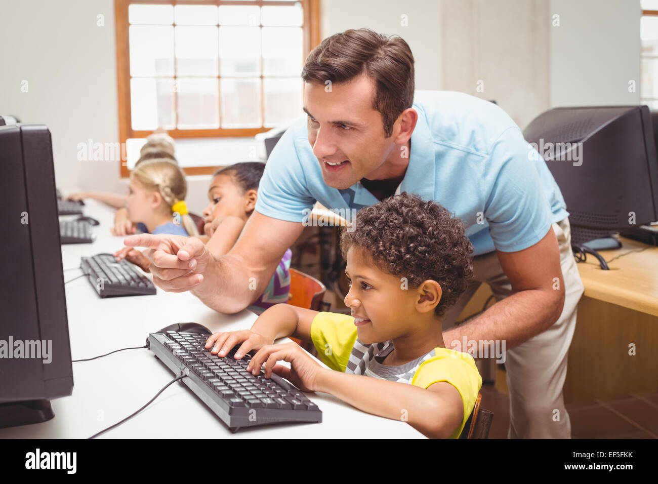 Cute pupils in computer class with teacher Stock Photo - Alamy