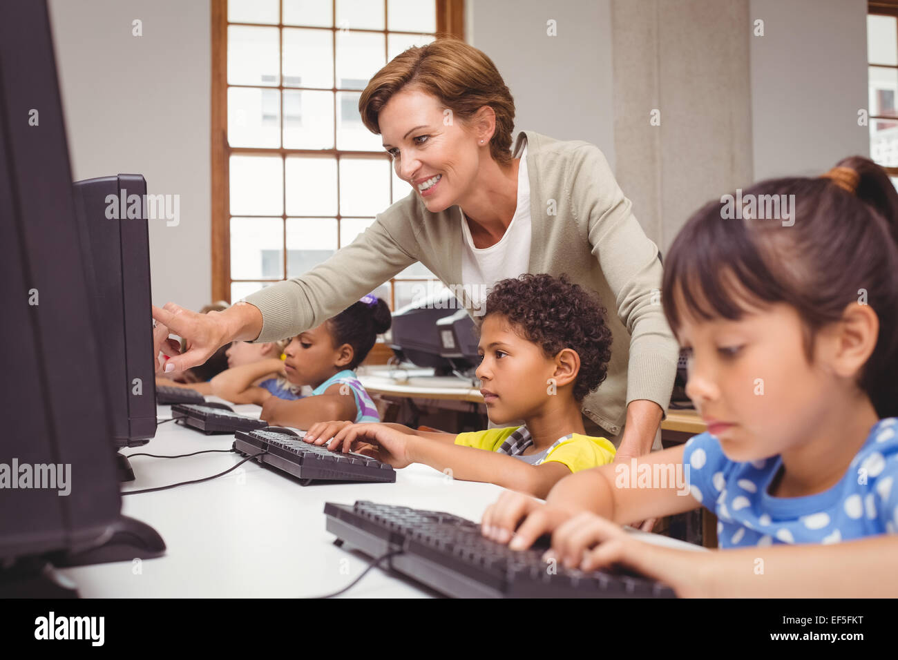 Cute pupils in computer class with teacher Stock Photo - Alamy