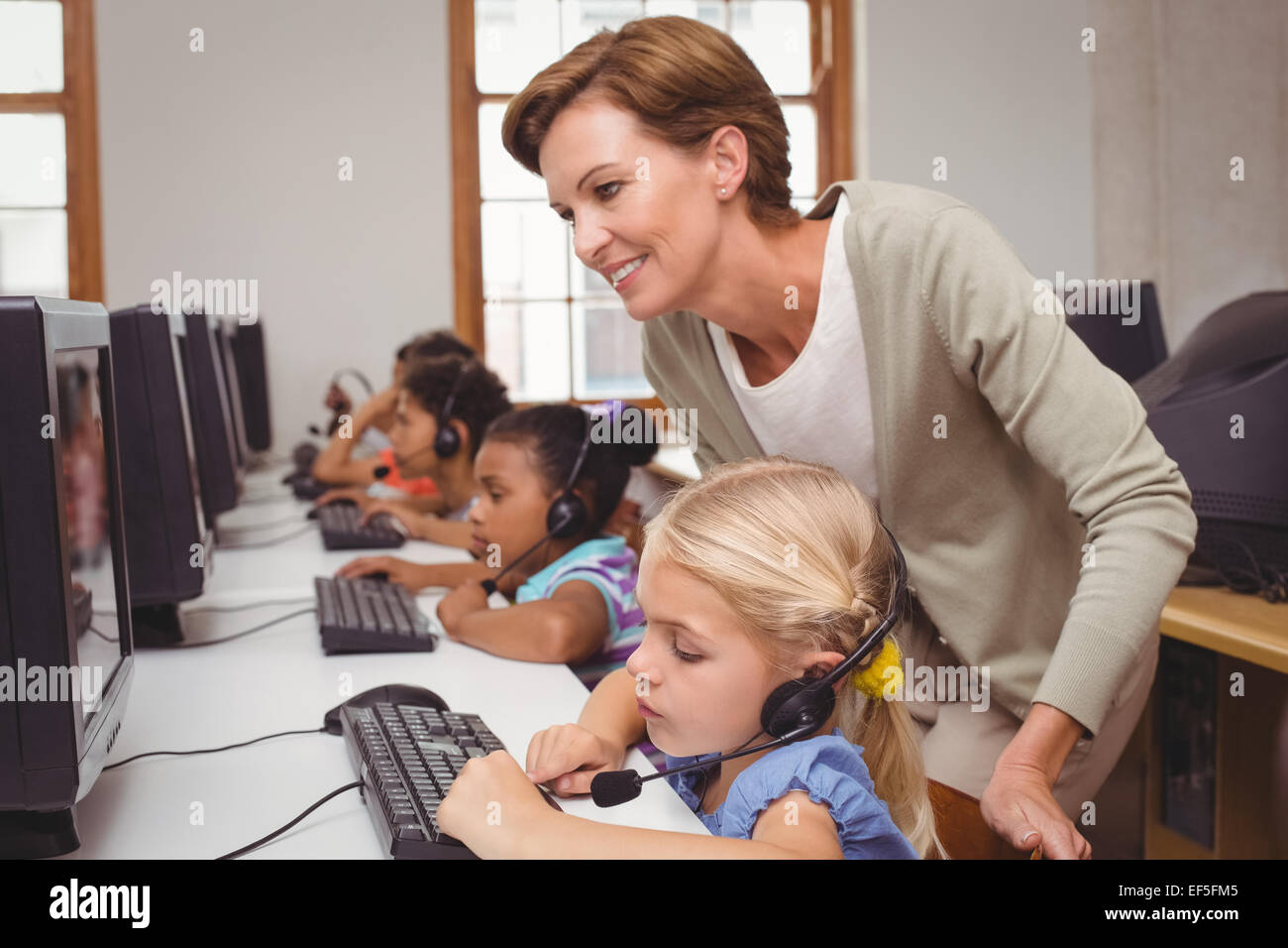 Cute pupils in computer class with teacher Stock Photo - Alamy
