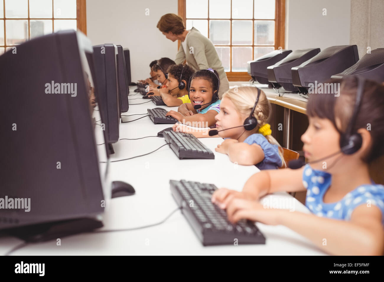 Cute pupils in computer class with teacher Stock Photo - Alamy